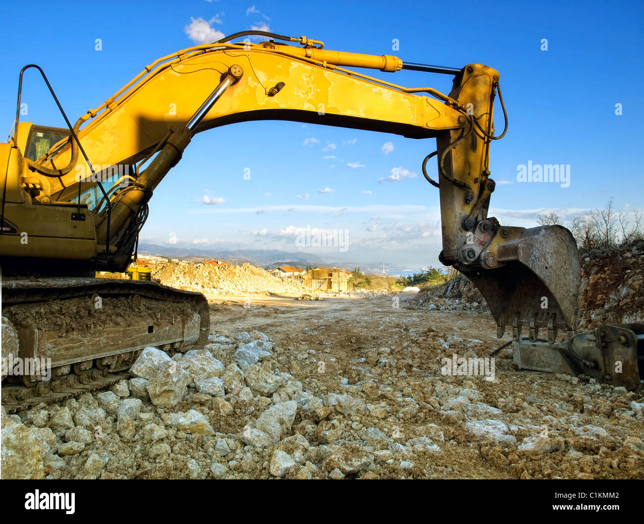 Digger machine at the construction site under blue sky Stock Photo - Alamy