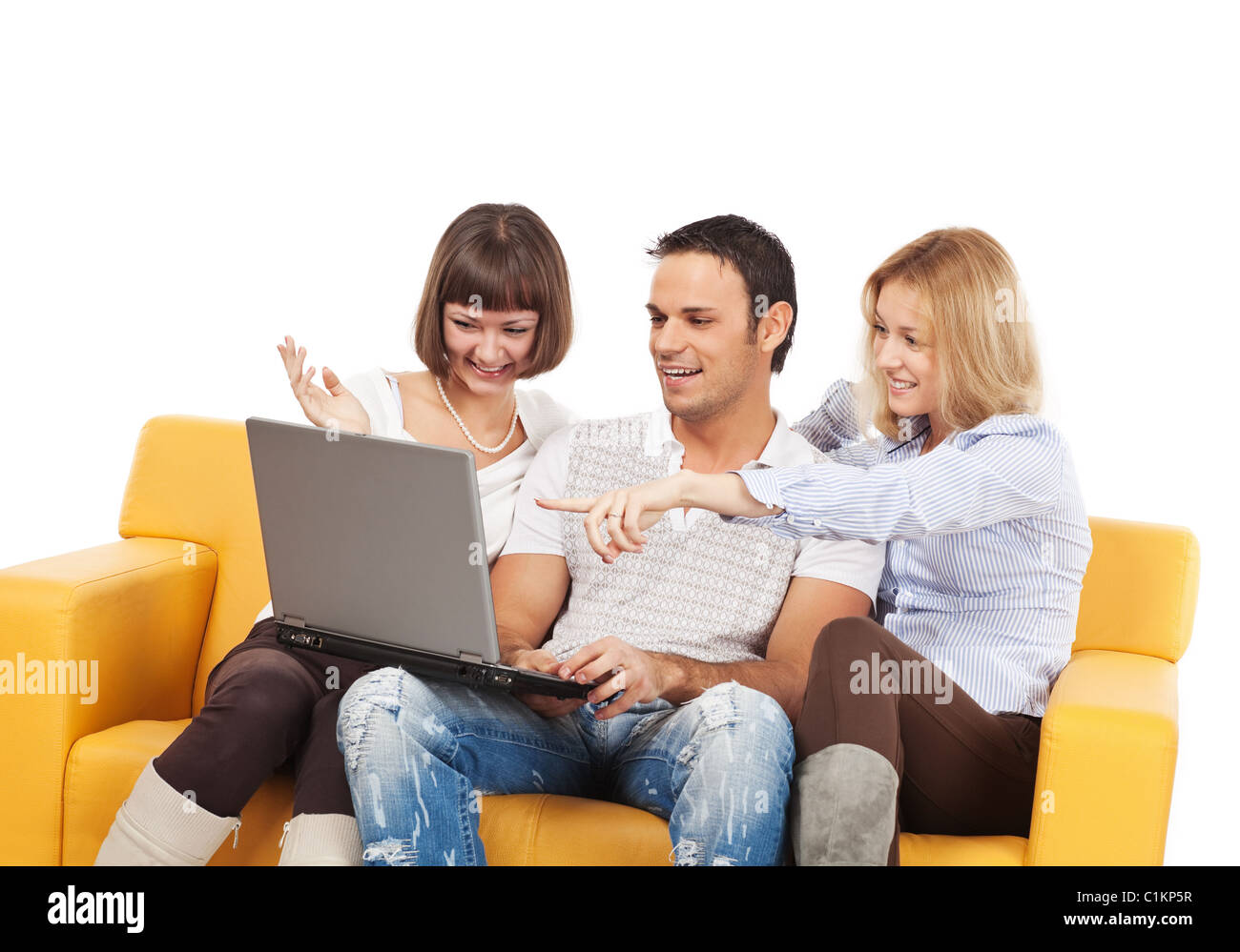 Three amused people with laptop computer sit on yellow sofa Stock Photo ...