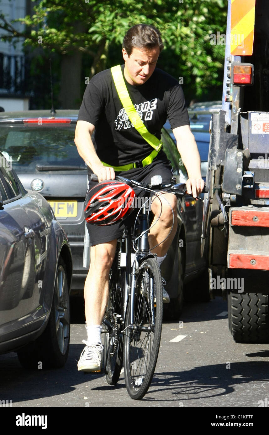 David Cameron jumps on his bike without wearing his helmet after ...