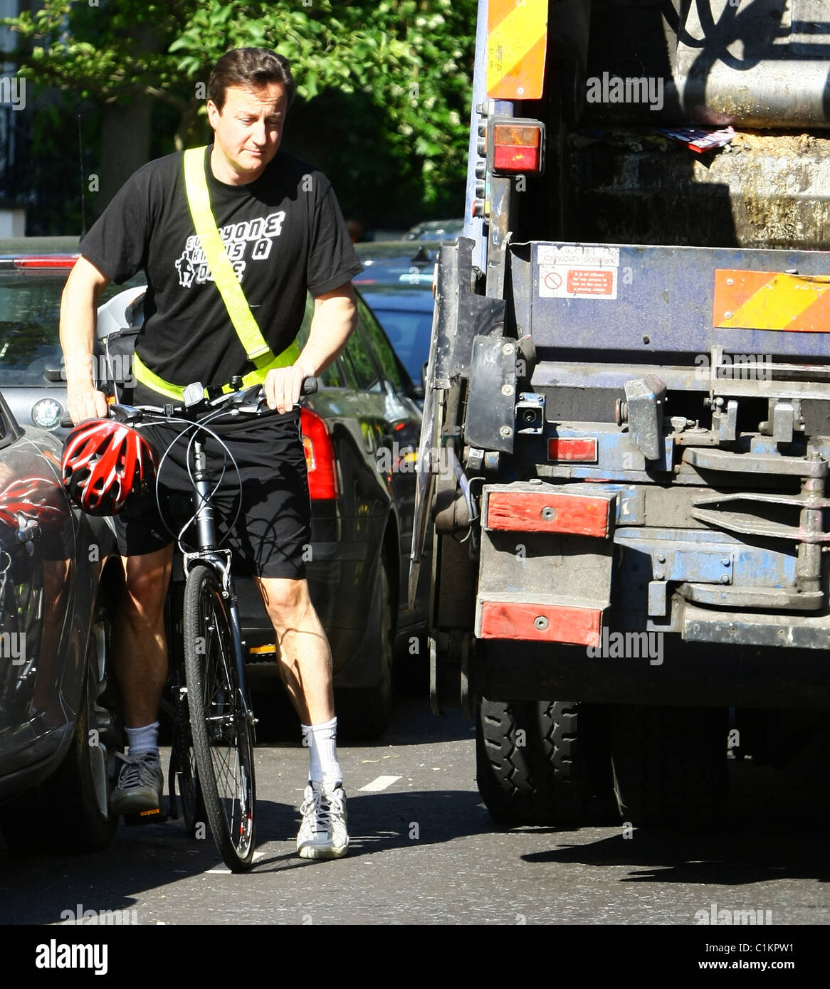 David Cameron jumps on his bike without wearing his helmet after ...