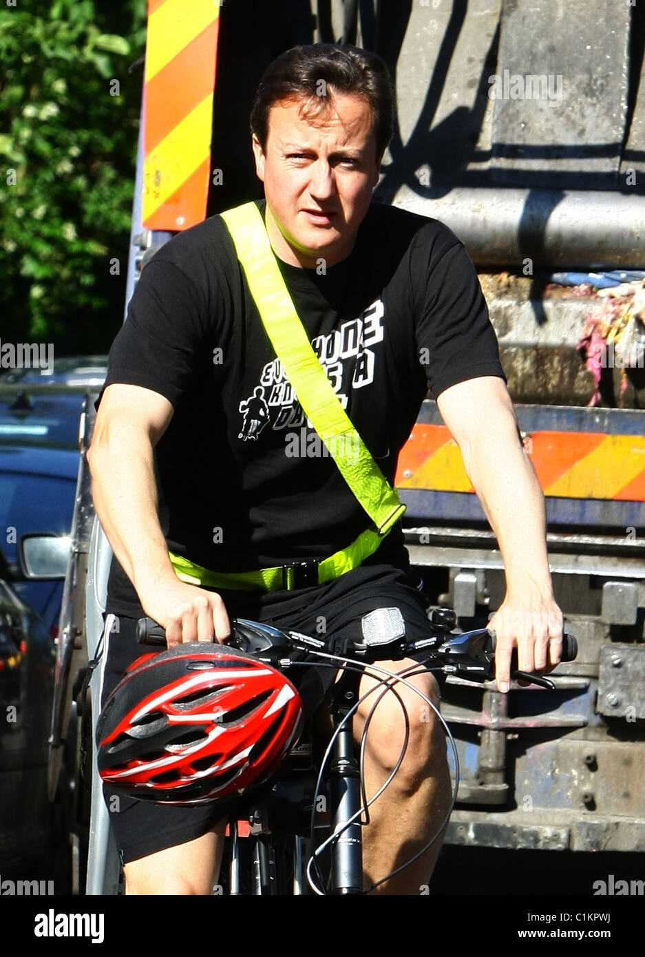 David Cameron jumps on his bike without wearing his helmet after ...