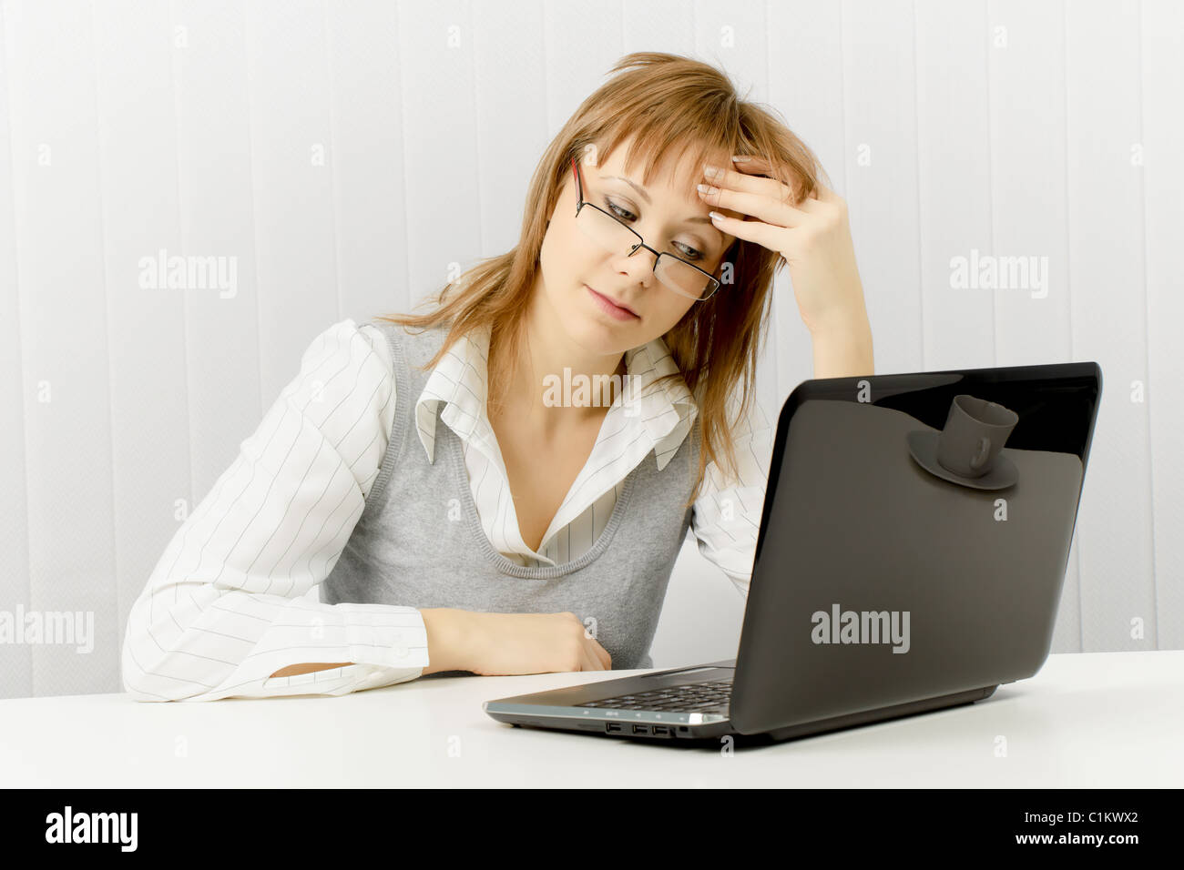 tired worker in the office. Disheveled girl with laptop Stock Photo - Alamy