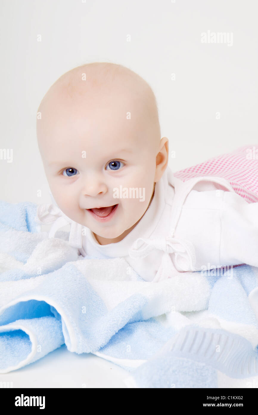 blue-eyed happy baby with a blue towel on the floor Stock Photo - Alamy