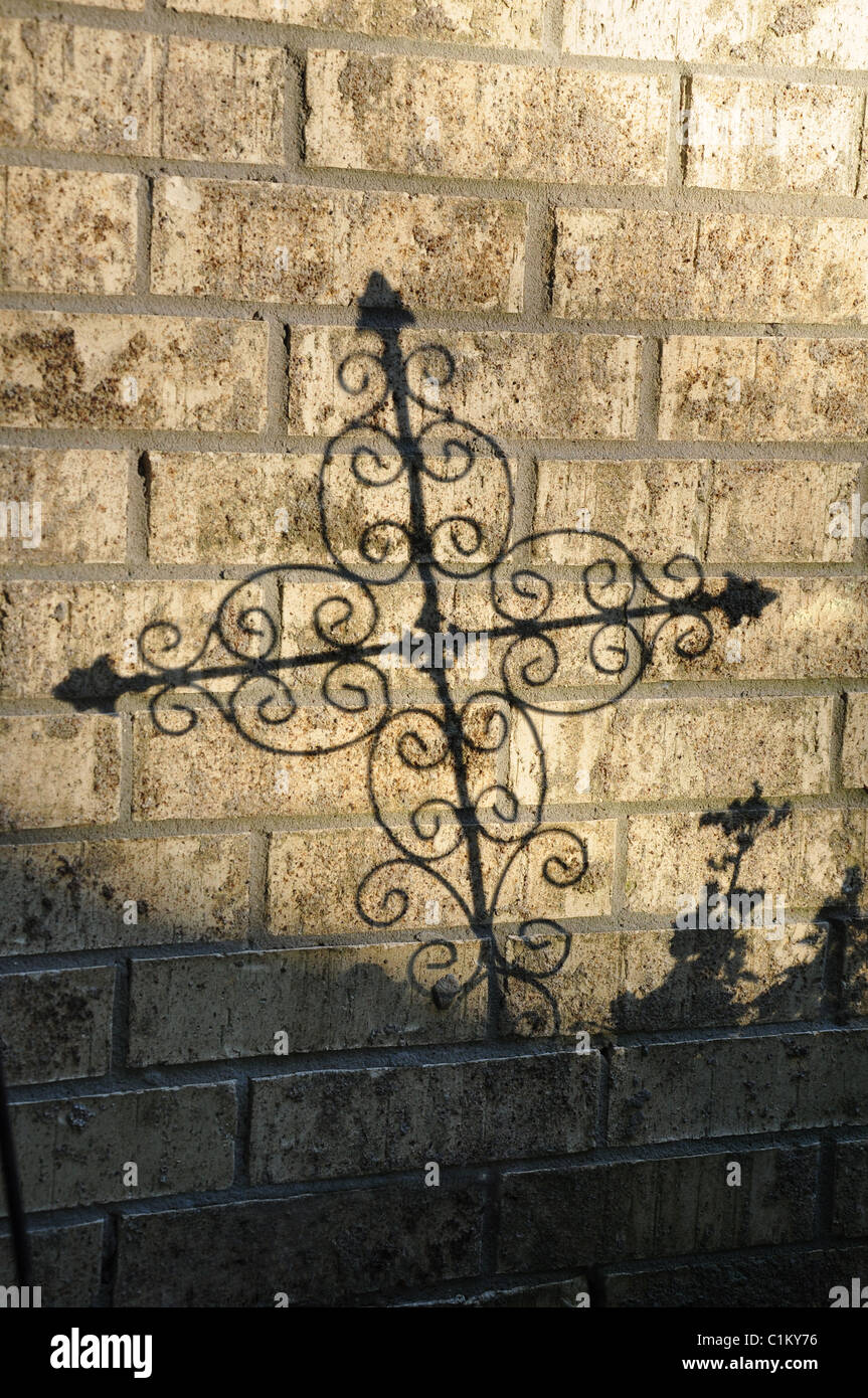 shadow of a scroll cross on a white brick wall in the sunlight Stock ...