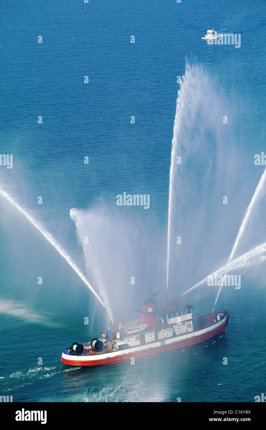 United States, New York City, tug boat with all fire hoses switched on ...