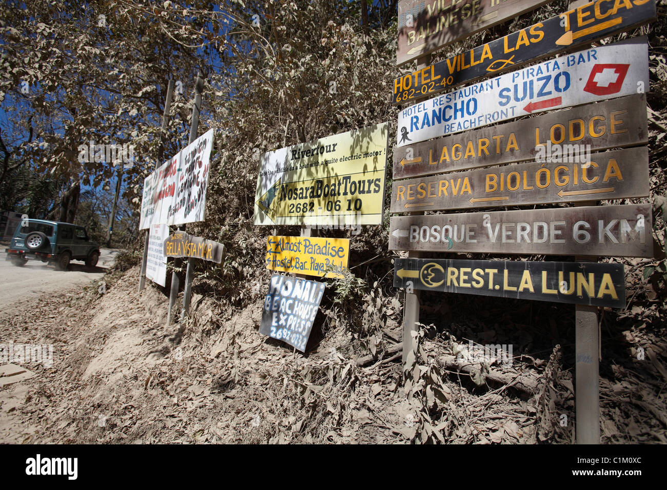 Hotel and lodge signs on a dusty dirt road near Ostional on the west ...