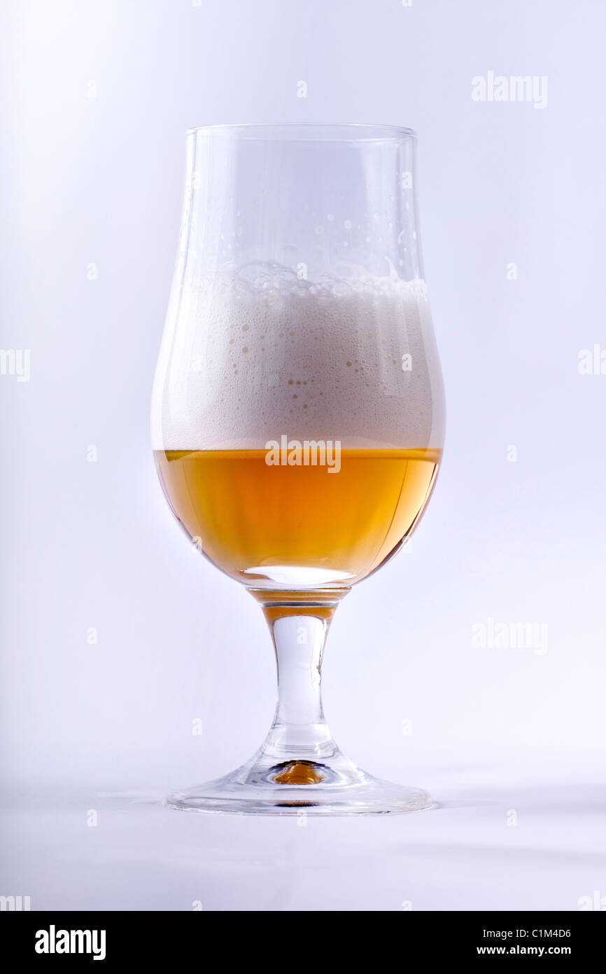 Close view of a glass being filled with beer isolated on a white ...