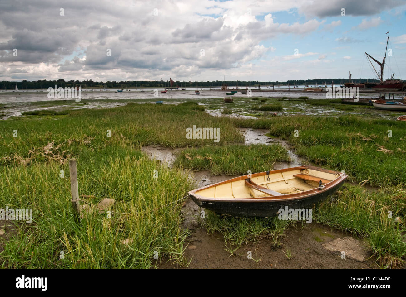 Tethered rowing boat on the mud at low tide Stock Photo - Alamy