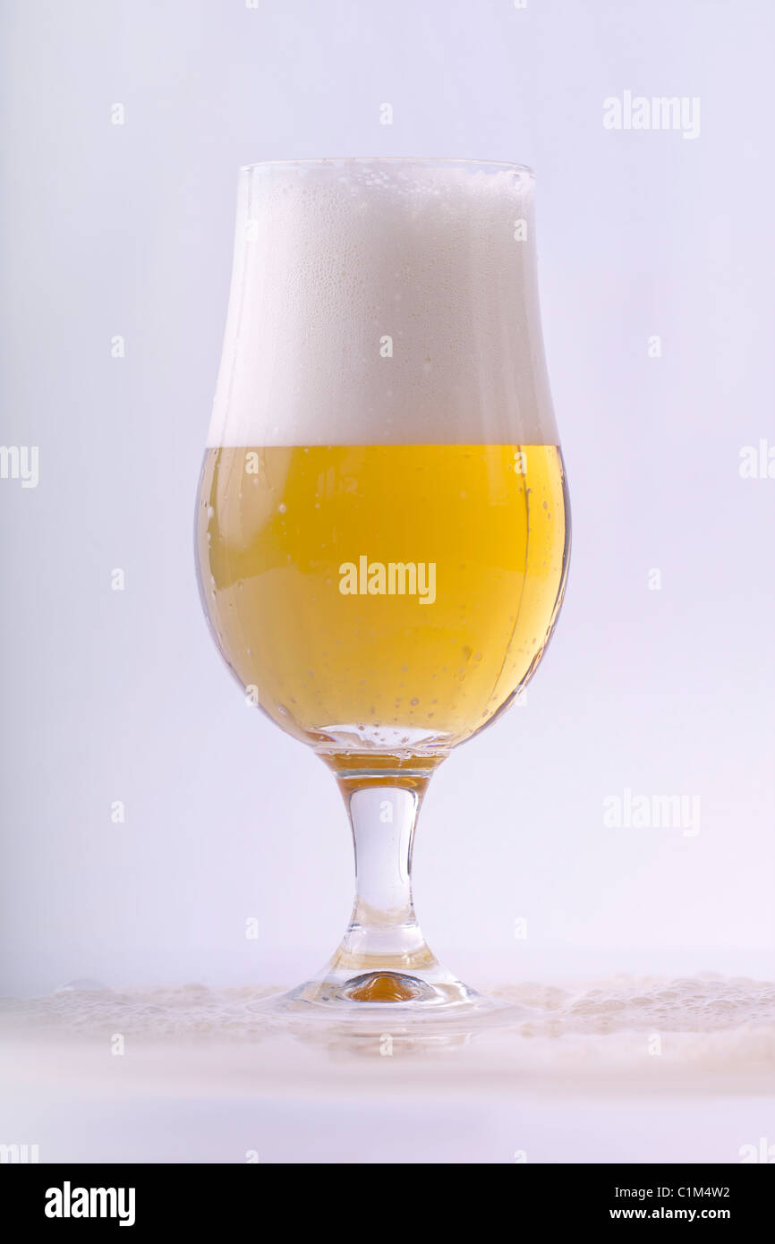 Close view of a glass being filled with beer isolated on a white ...