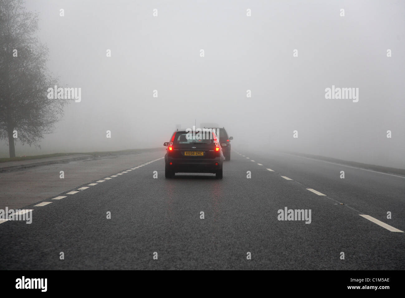 Cars driving in fog Stock Photo - Alamy