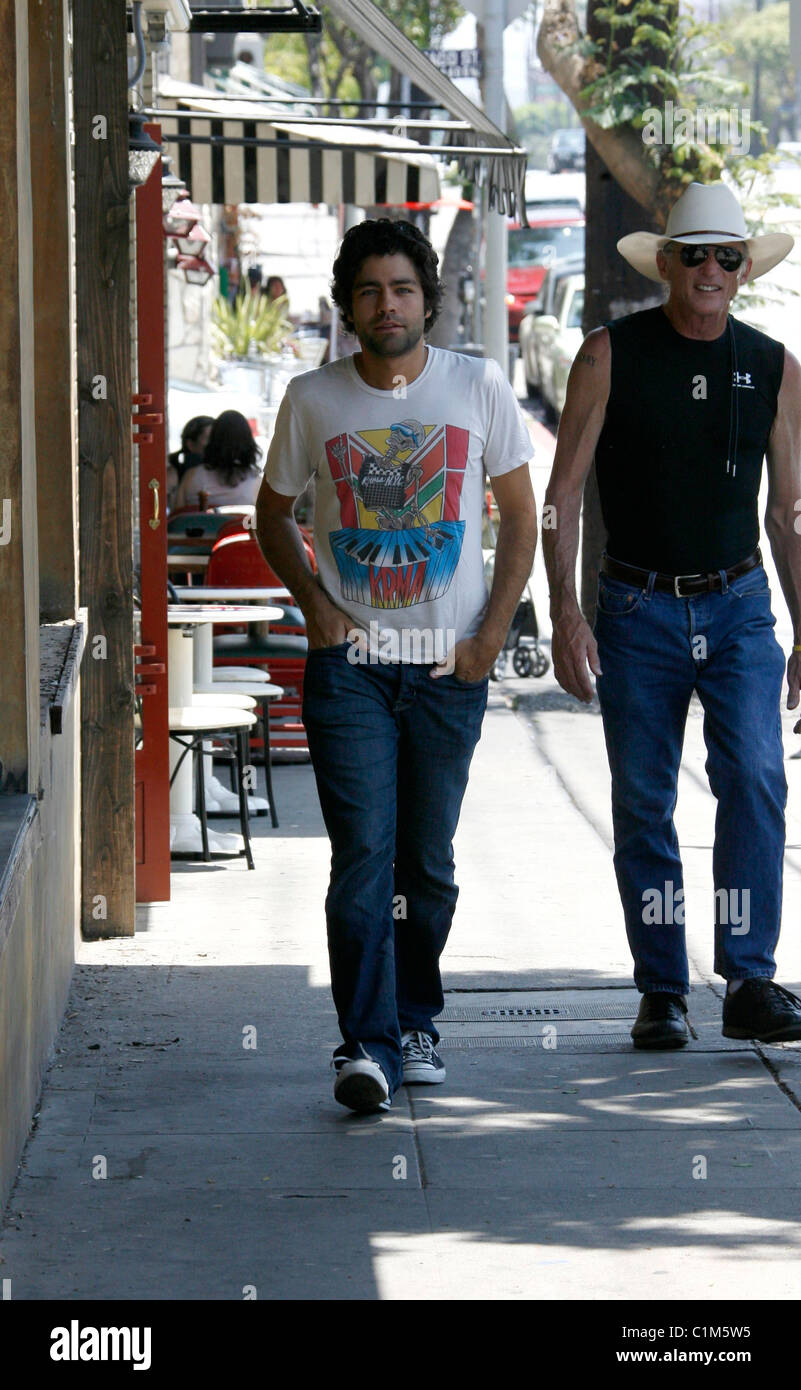 Adam Grenier walking along the pavement with his hands in his pockets ...