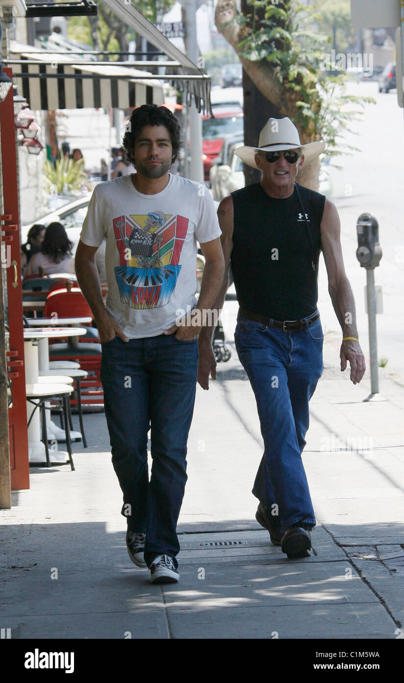 Adam Grenier walking along the pavement with his hands in his pockets ...