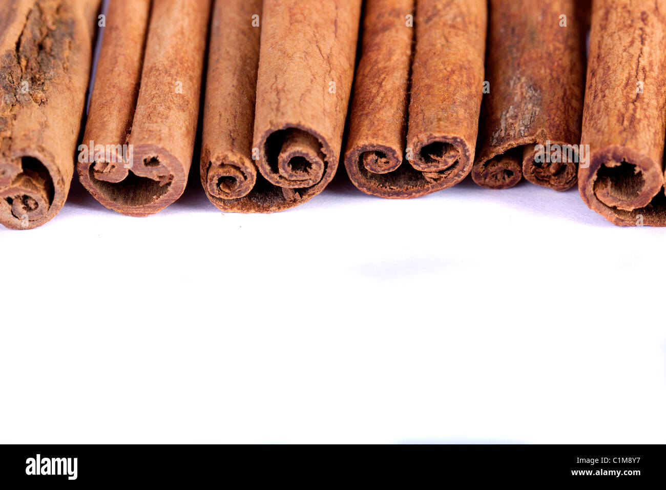 View of a bunch of cinnamon spice quills isolated on a white background ...
