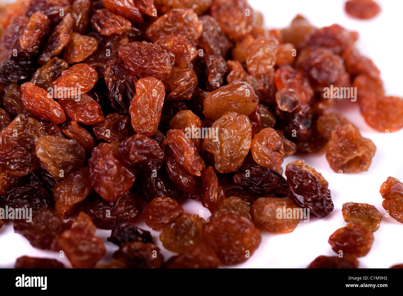 Close view of a pile of dry raisins isolated on a white background ...