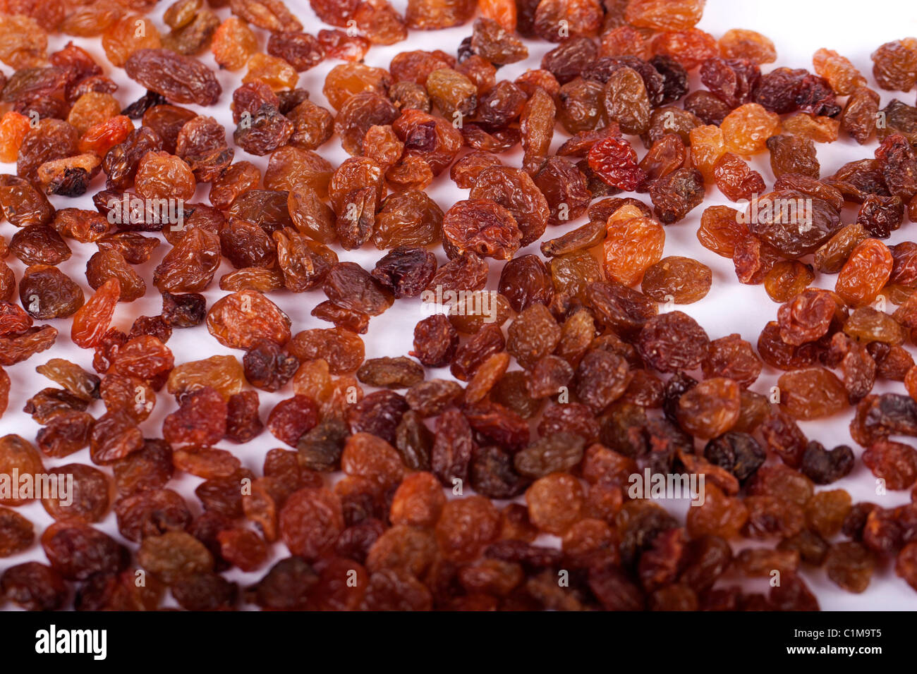 Close view of a pile of dry raisins isolated on a white background ...