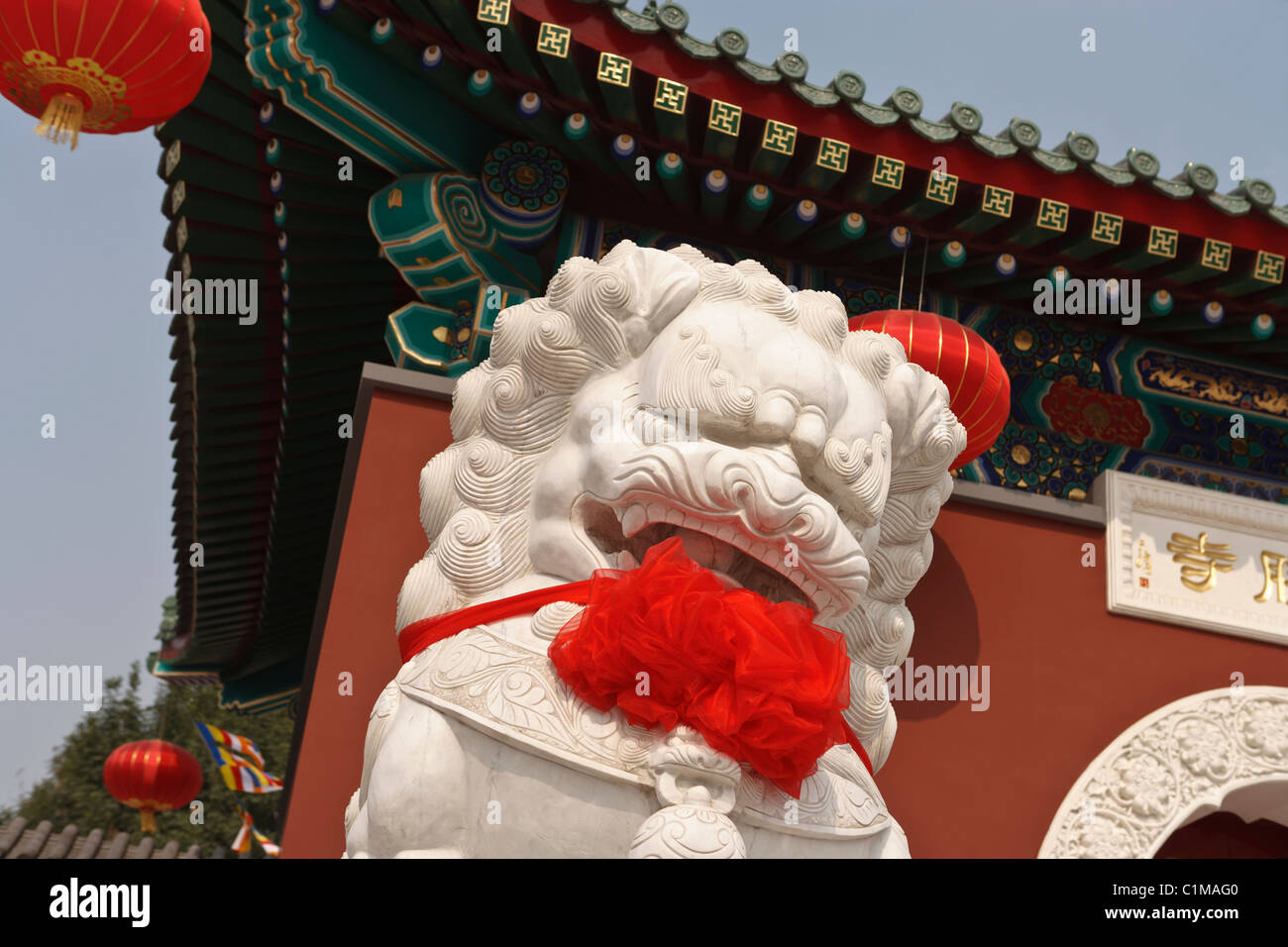 A traditional sculpted Chinese lion with a red ribbon at the Dabei ...
