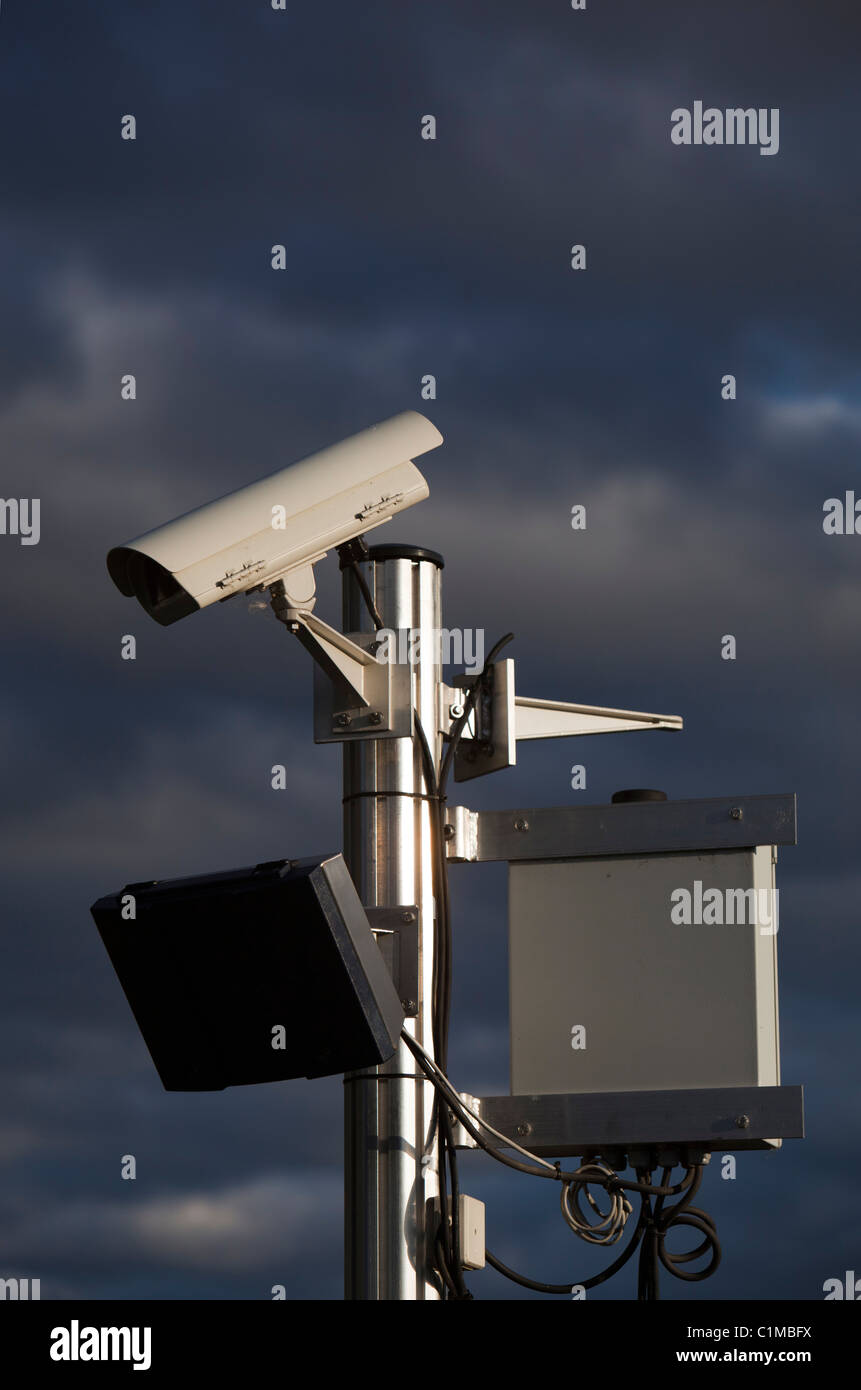 Remotely controlled surveillance camera against dark stormy sky ...