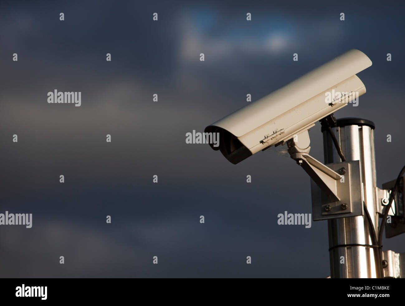 Remotely controlled surveillance camera against dark stormy sky ...