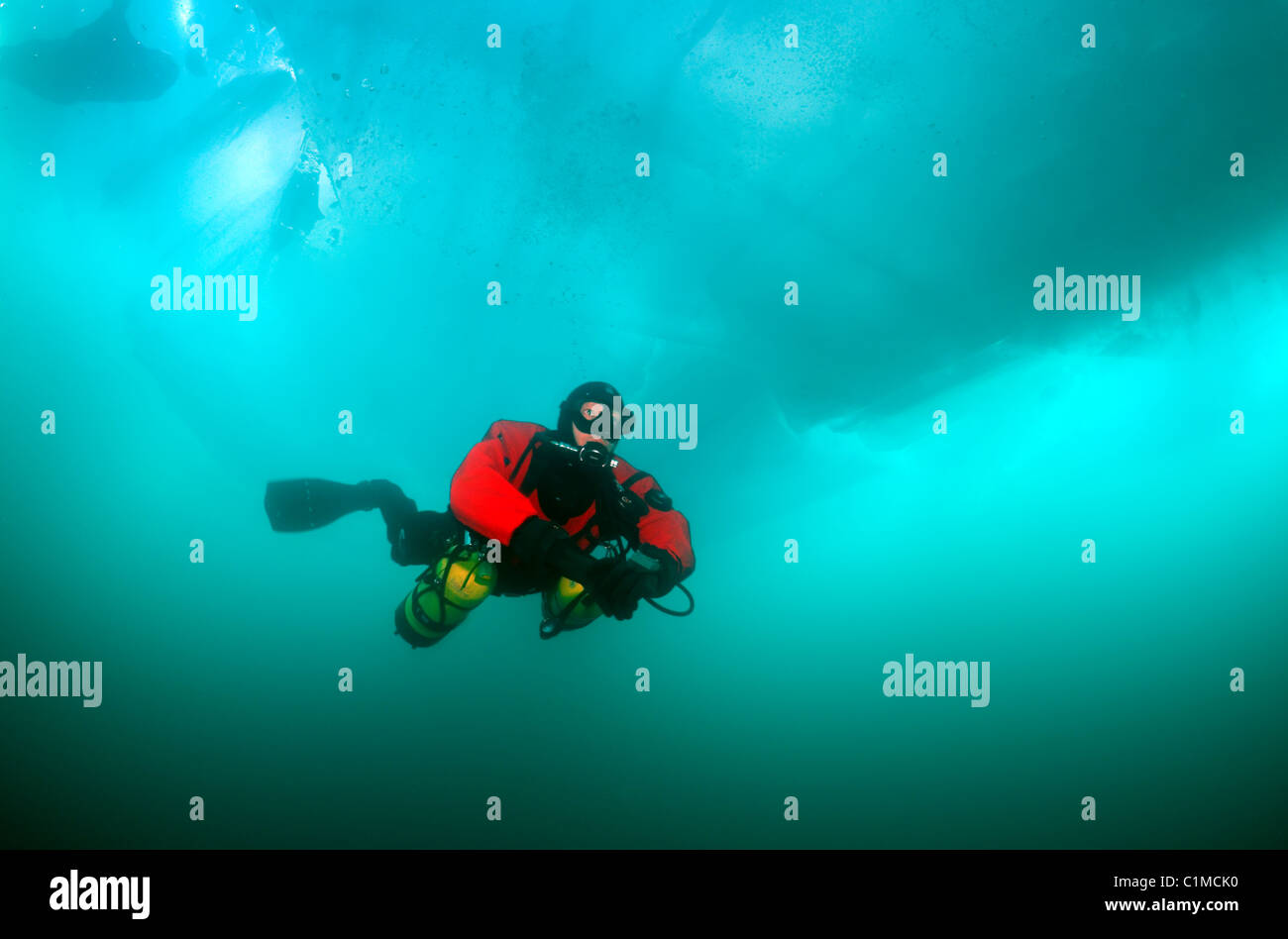 Scuba diver in sidemount swim under ice. ice-diving, in lake Baikal ...