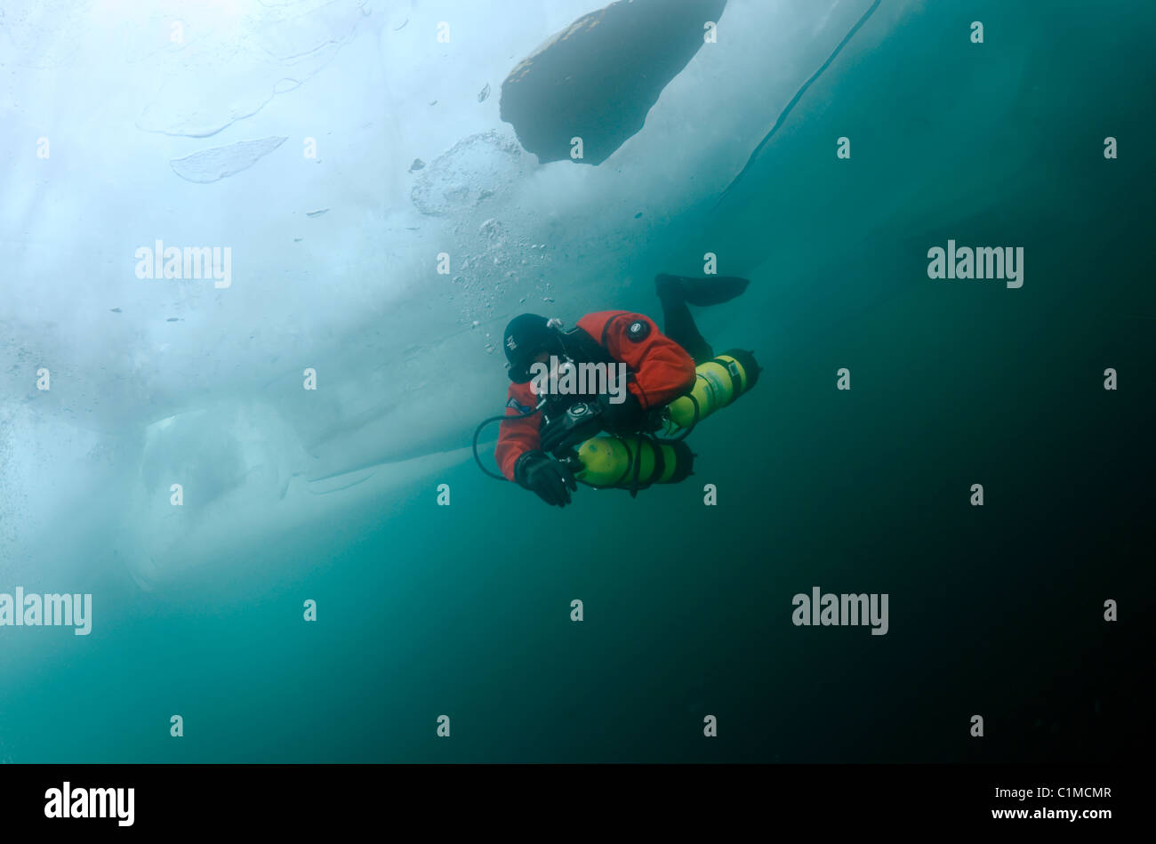 Scuba diver in sidemount swim under ice. ice-diving, in lake Baikal ...
