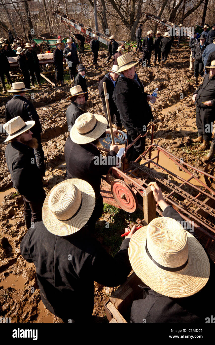 Amish men bid on farm equipment during the Annual Mud Sale to support ...