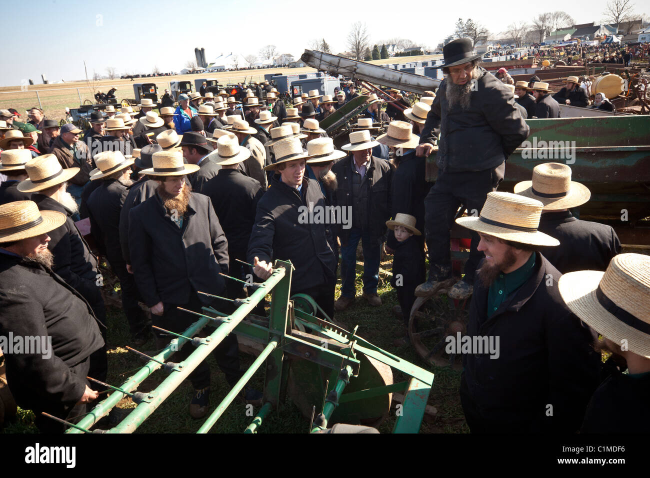 Amish men bid on farm equipment during the Annual Mud Sale to support ...