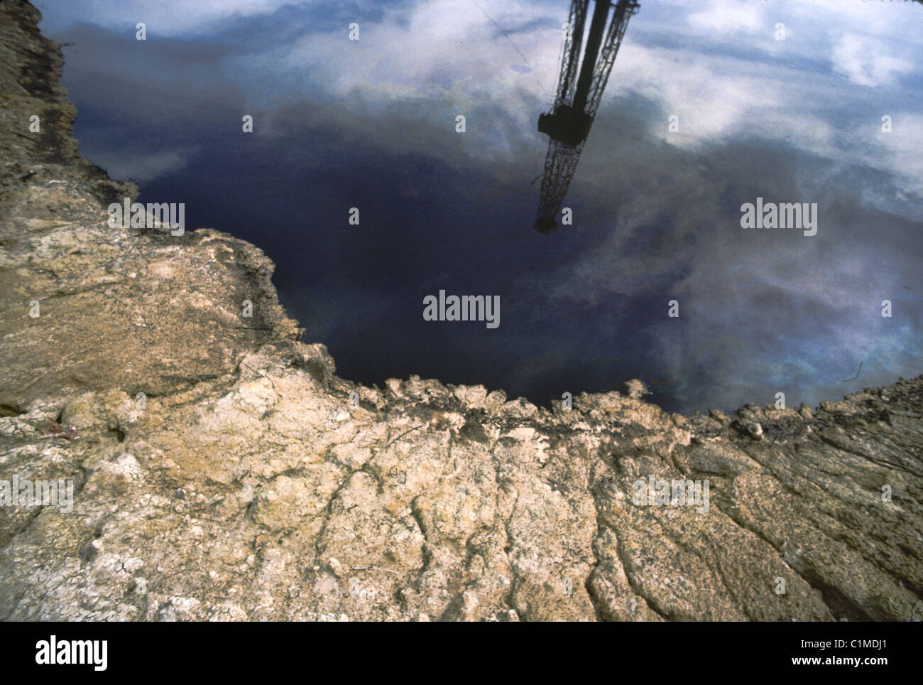 Oil rig reflected in mud pit at drilling site Stock Photo - Alamy