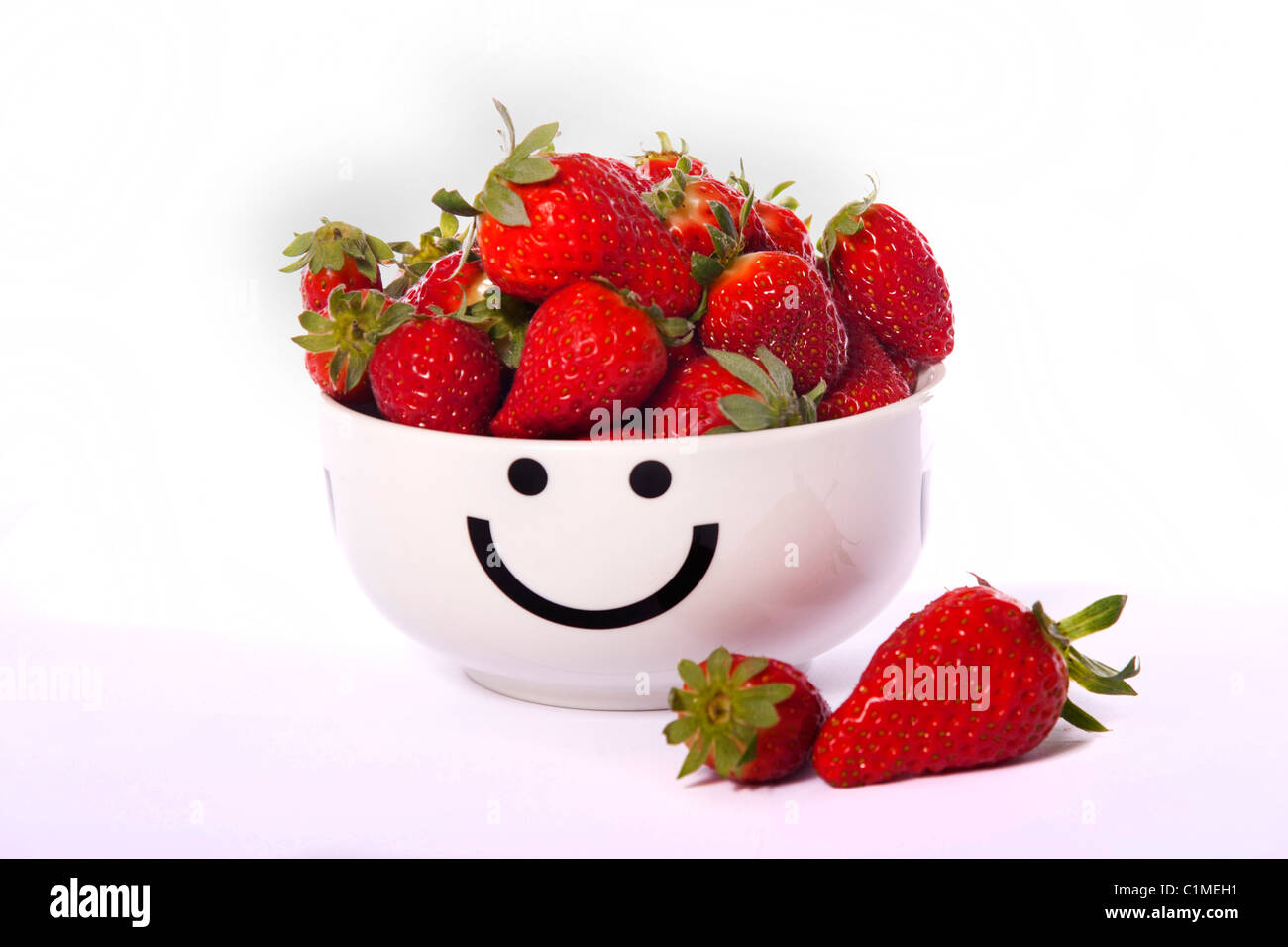 View of a smiley bowl filled with strawberries isolated on a white ...