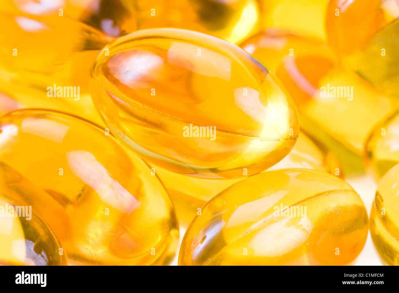 Transparent gold fish oil pills close-up Stock Photo - Alamy