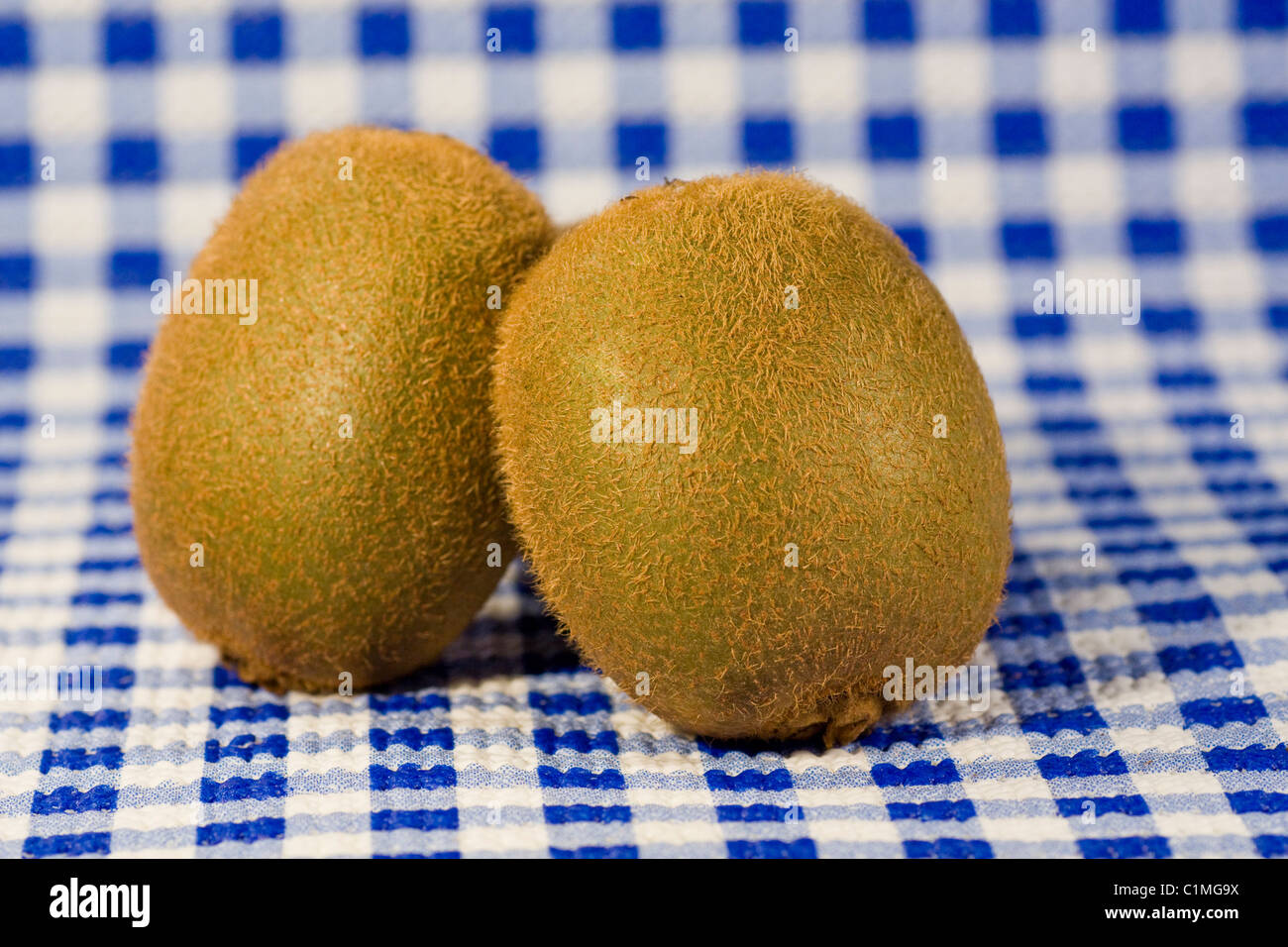 Two kiwis fruits isolated on the kitchen table Stock Photo - Alamy