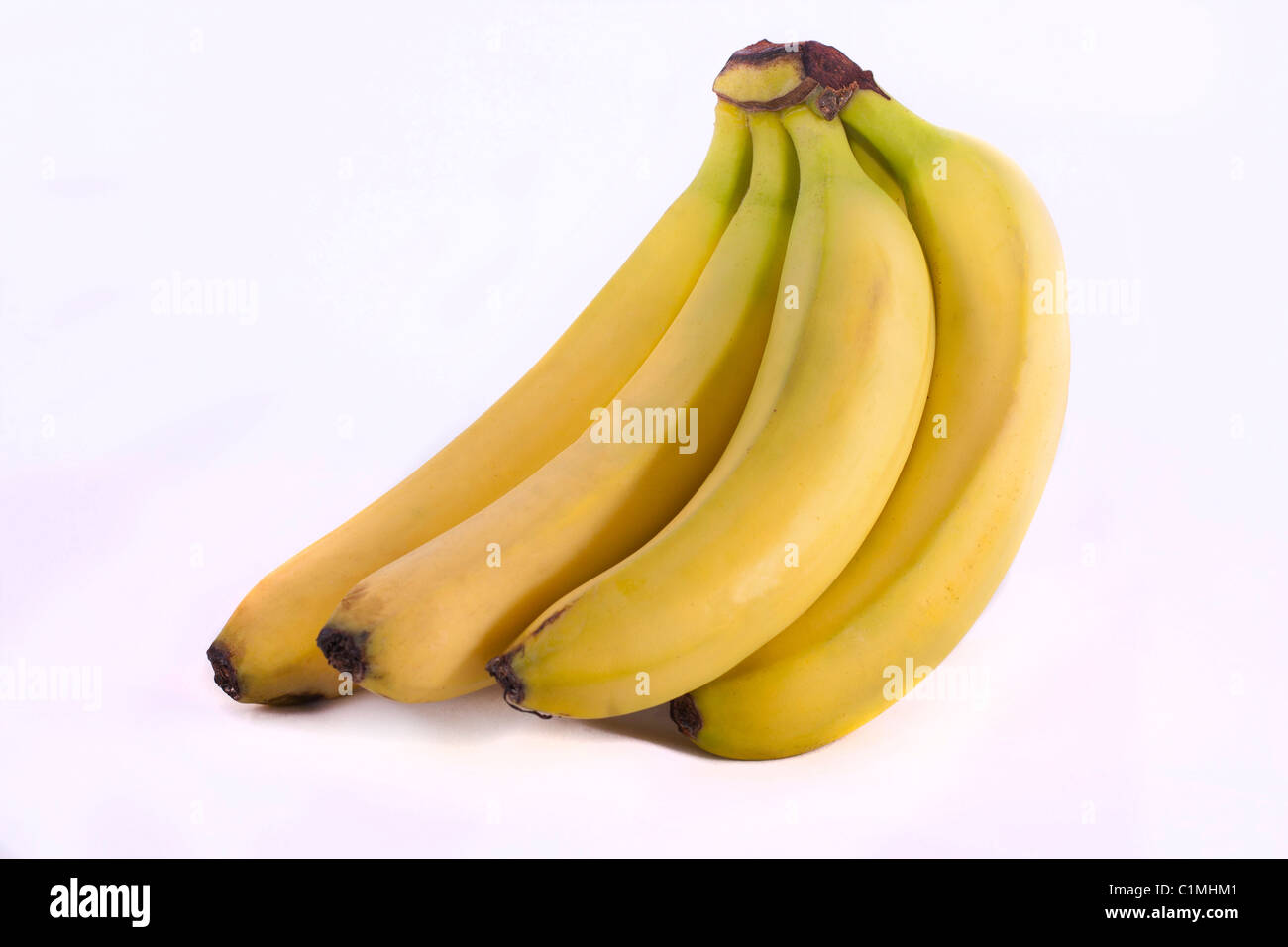 Close view of a bunch of yellow bananas isolated on a white background ...
