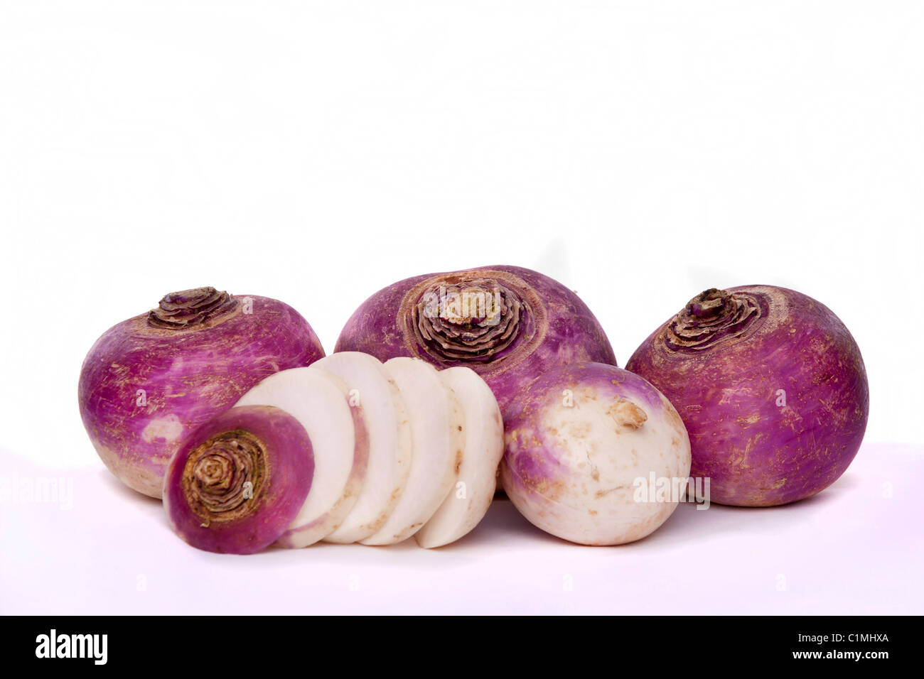 Detail view of a bunch of purple turnips isolated on a white background ...