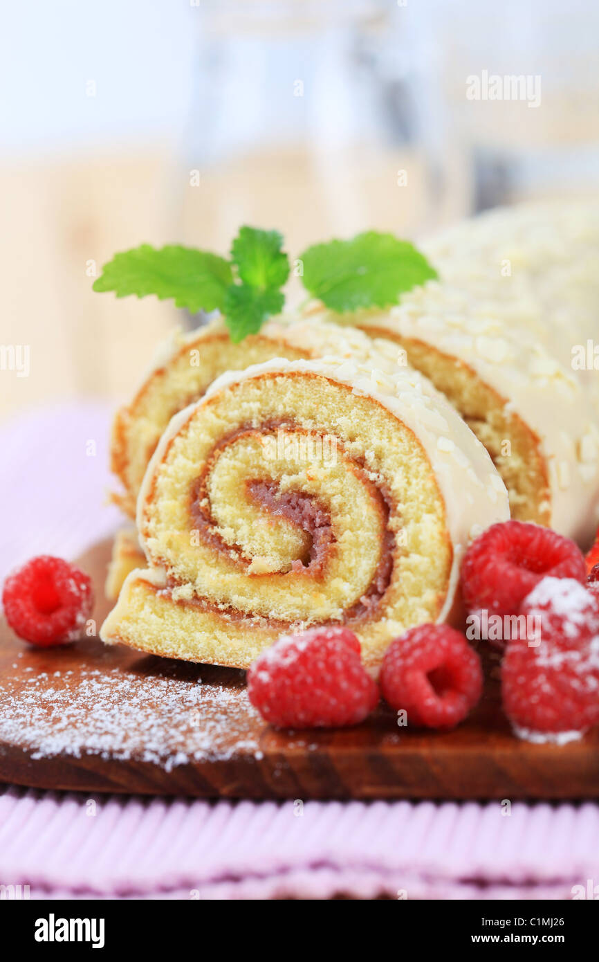 Swiss roll glazed with white chocolate icing Stock Photo - Alamy
