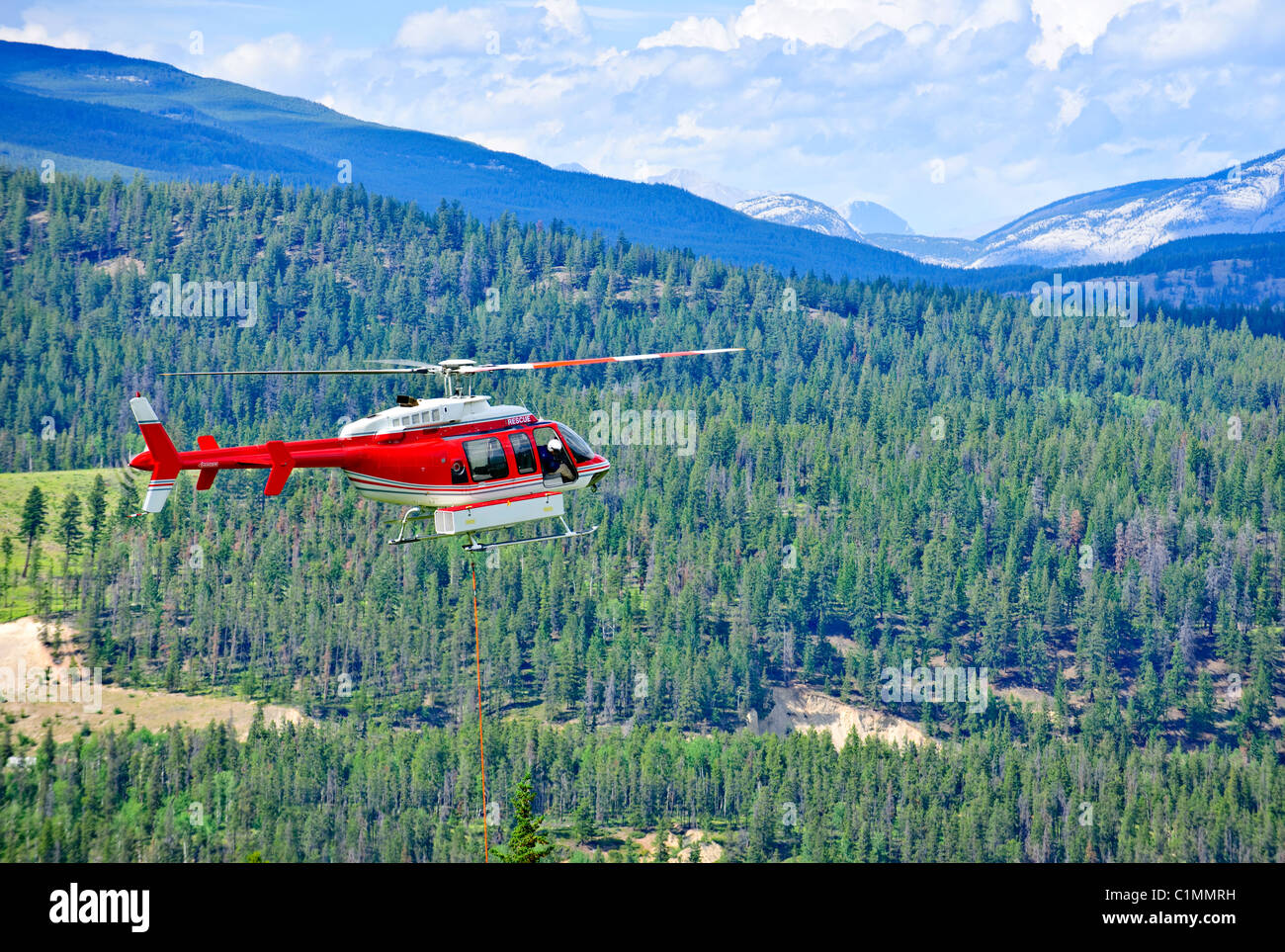Red rescue helicopter flying emergency mission in mountains, Alberta ...