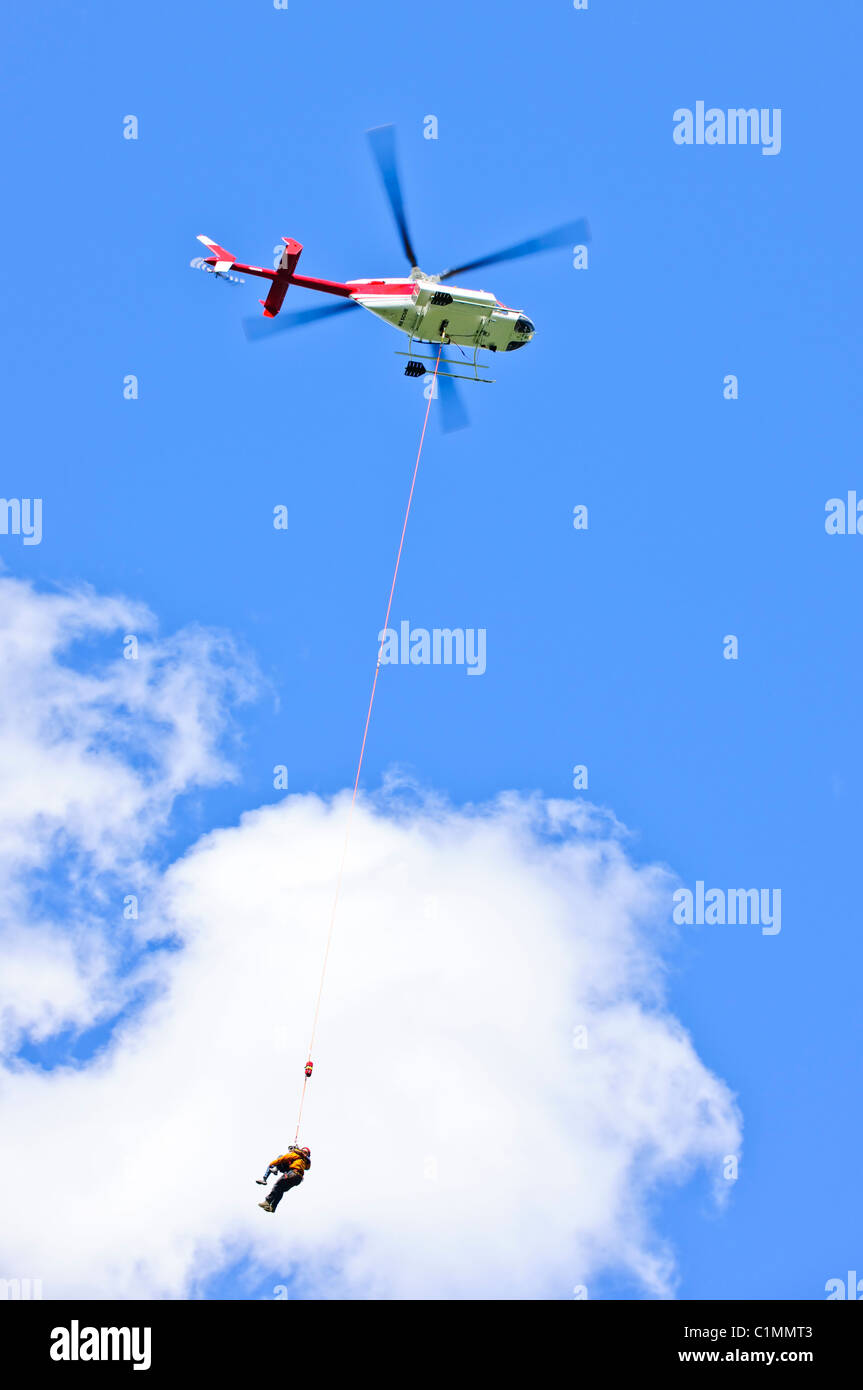 Rescue helicopter rescuing person by airlifting dangling on rope Stock ...