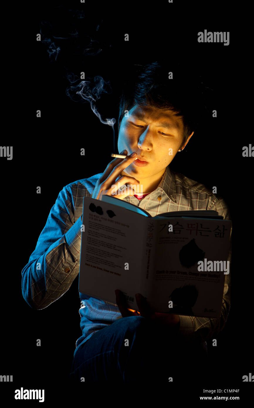 University student reading book with smoking cigarette Stock Photo - Alamy