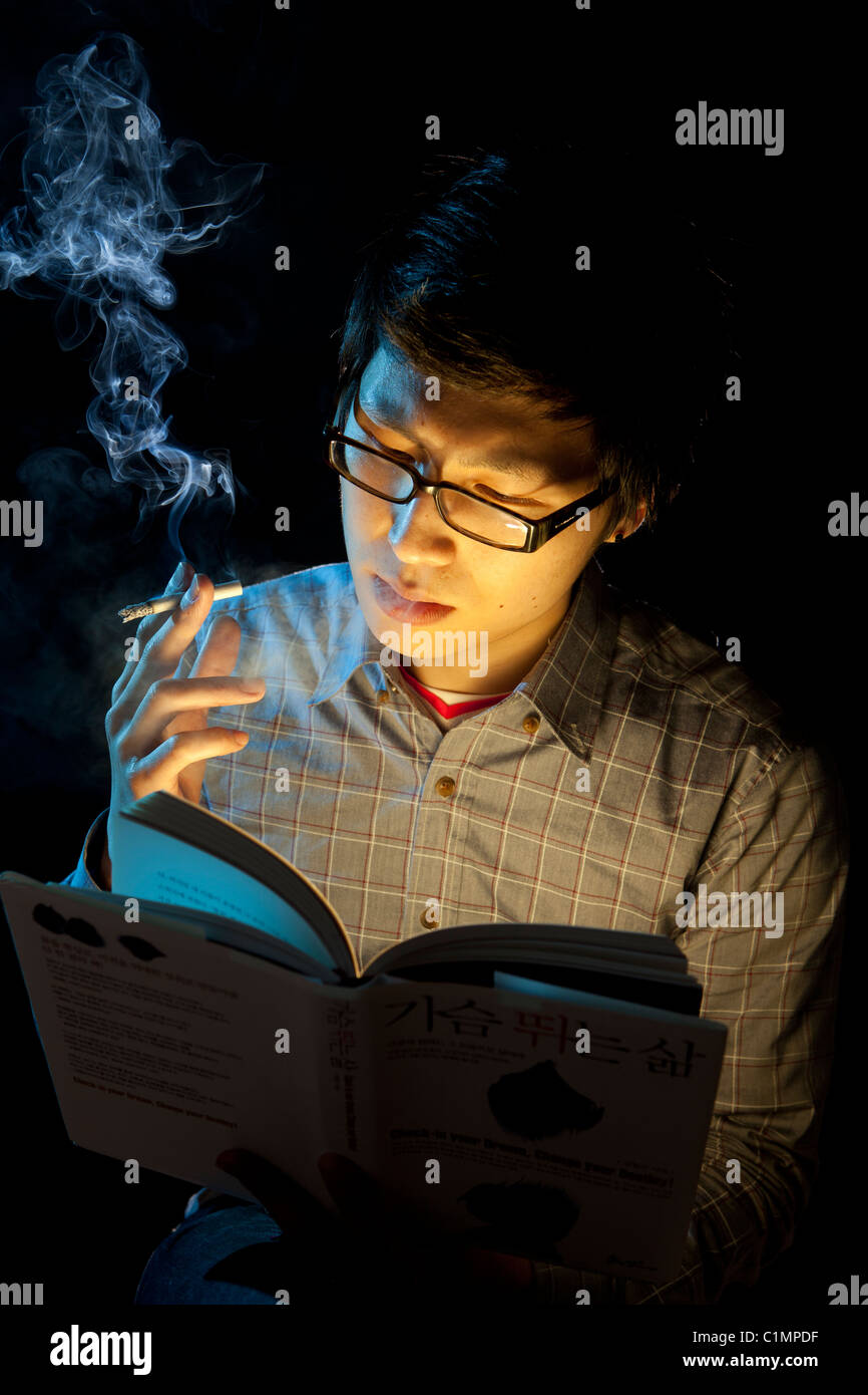 University student reading book with smoking cigarette Stock Photo - Alamy