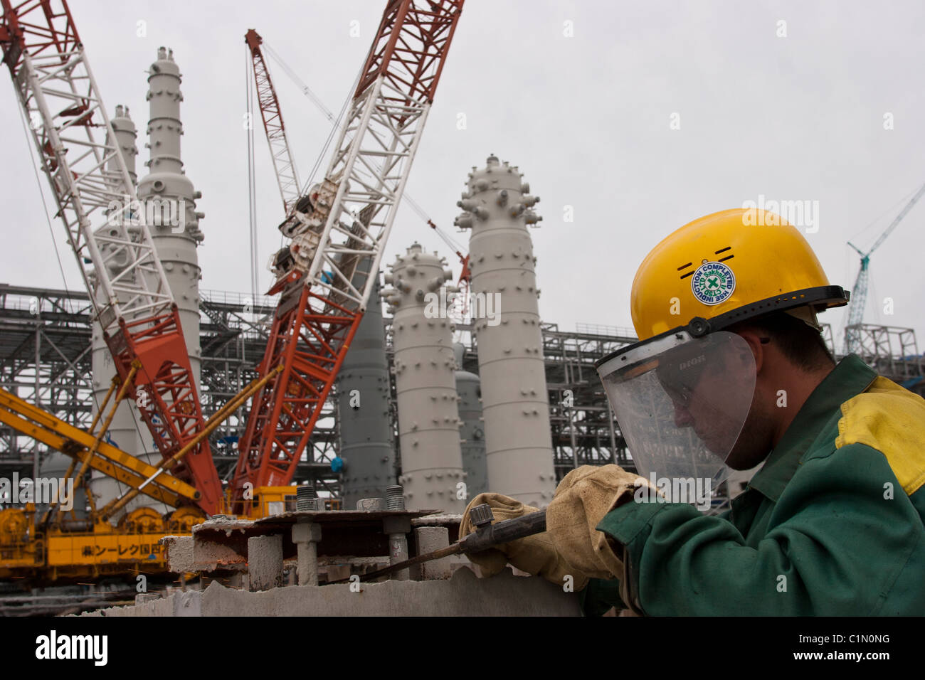 Workmen at work at the Sakenergy liquefied natural gas plant and oil ...