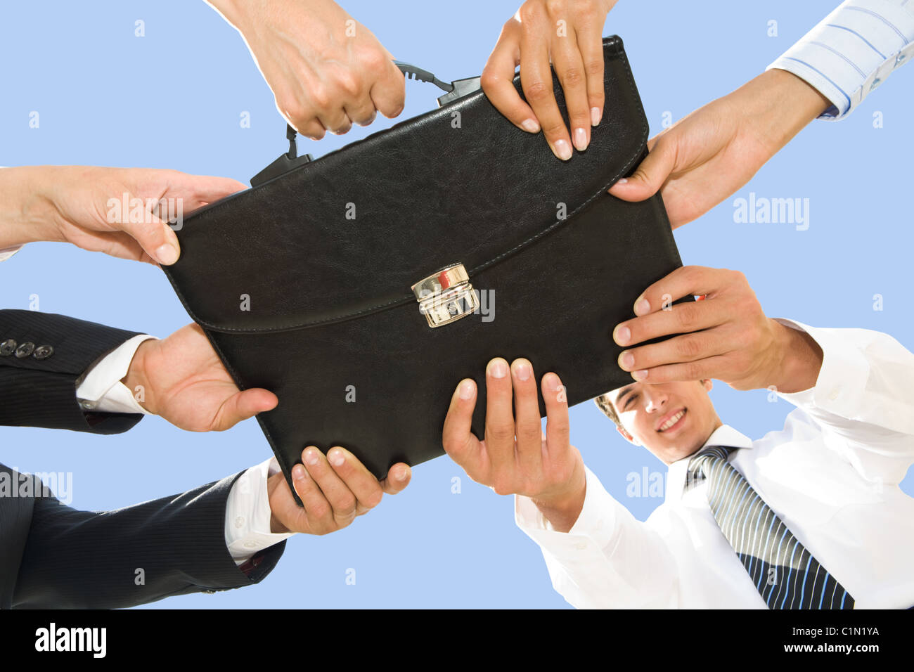 Below angle of people hands holding black leather briefcase ...