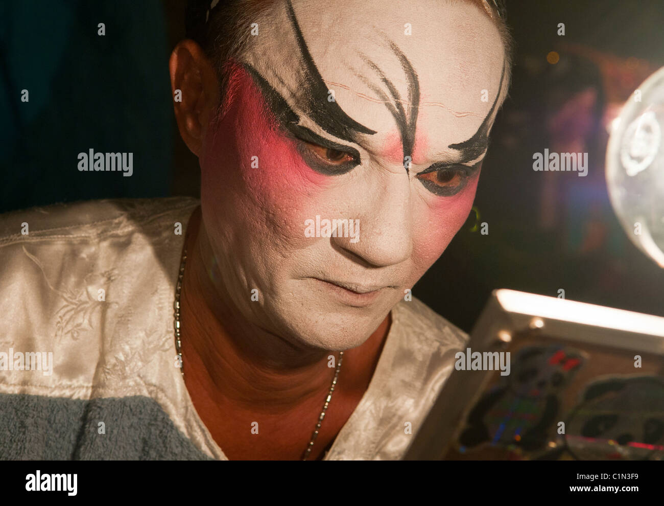 Chinese opera performer applies makeup backstage in Bangkok, Thailand ...
