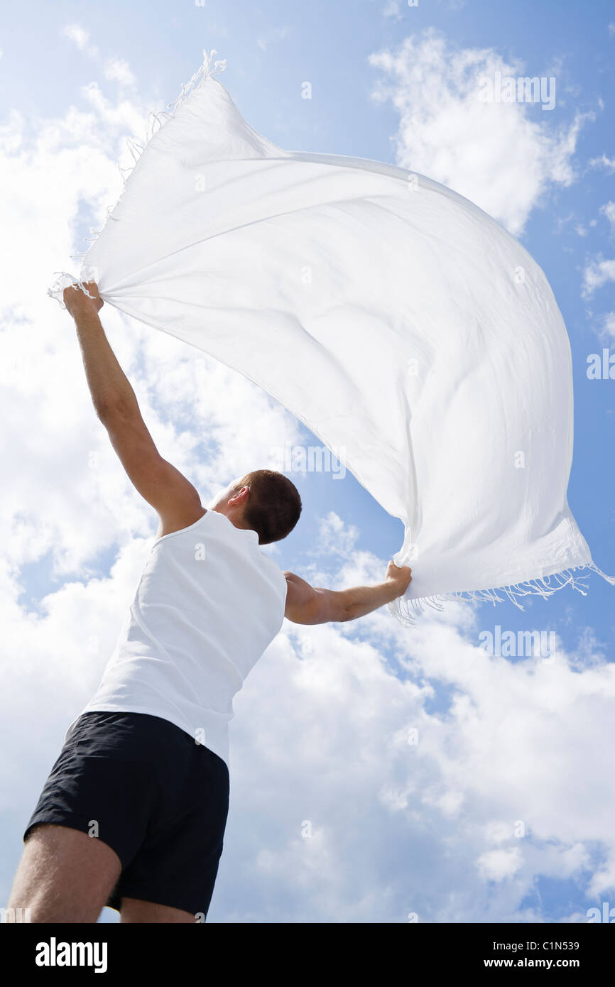 Man holding white blanket in wind Stock Photo - Alamy