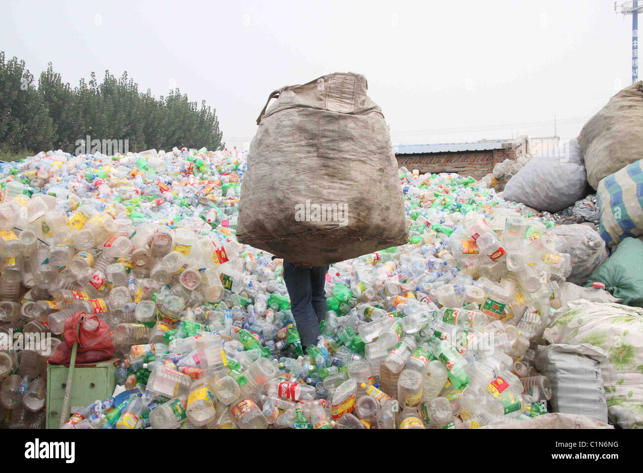 Garbage mountain A worker wades through mountains of trash at a refuse ...