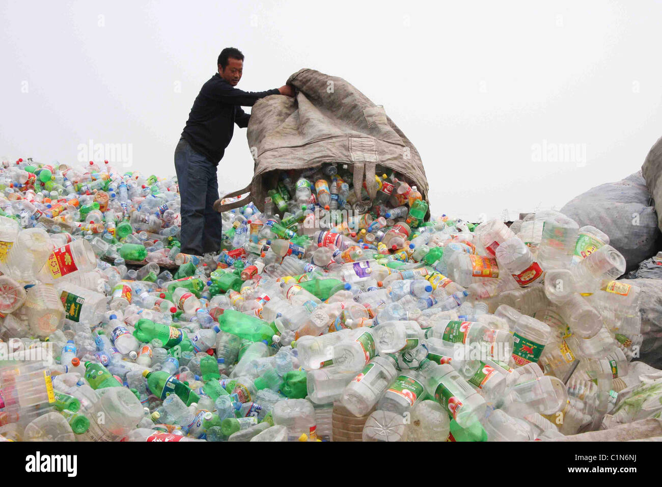 Garbage mountain A worker wades through mountains of trash at a refuse ...
