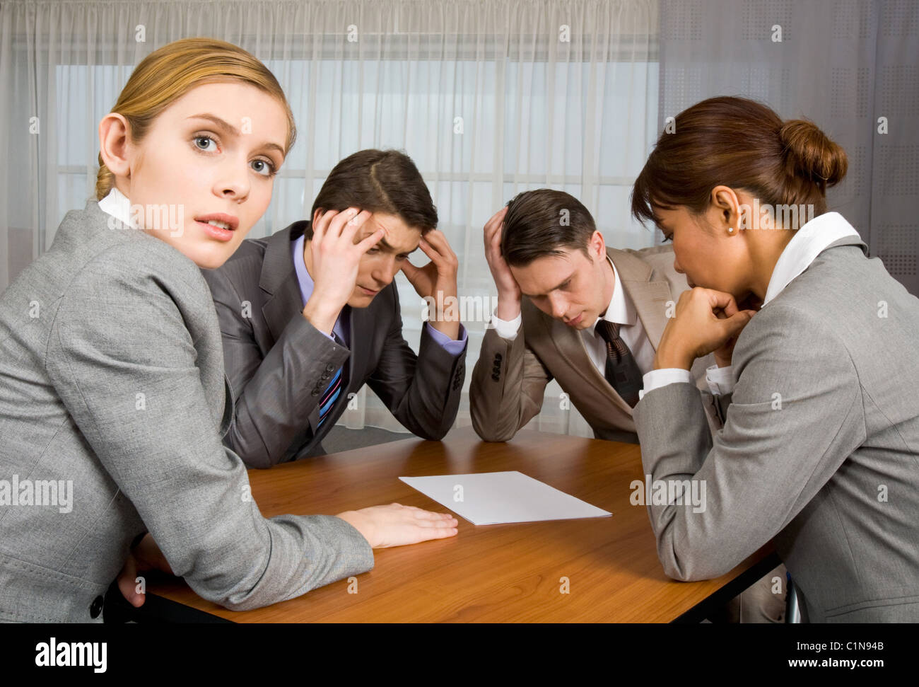 Portrait of business people sitting around table and brainstorming ...