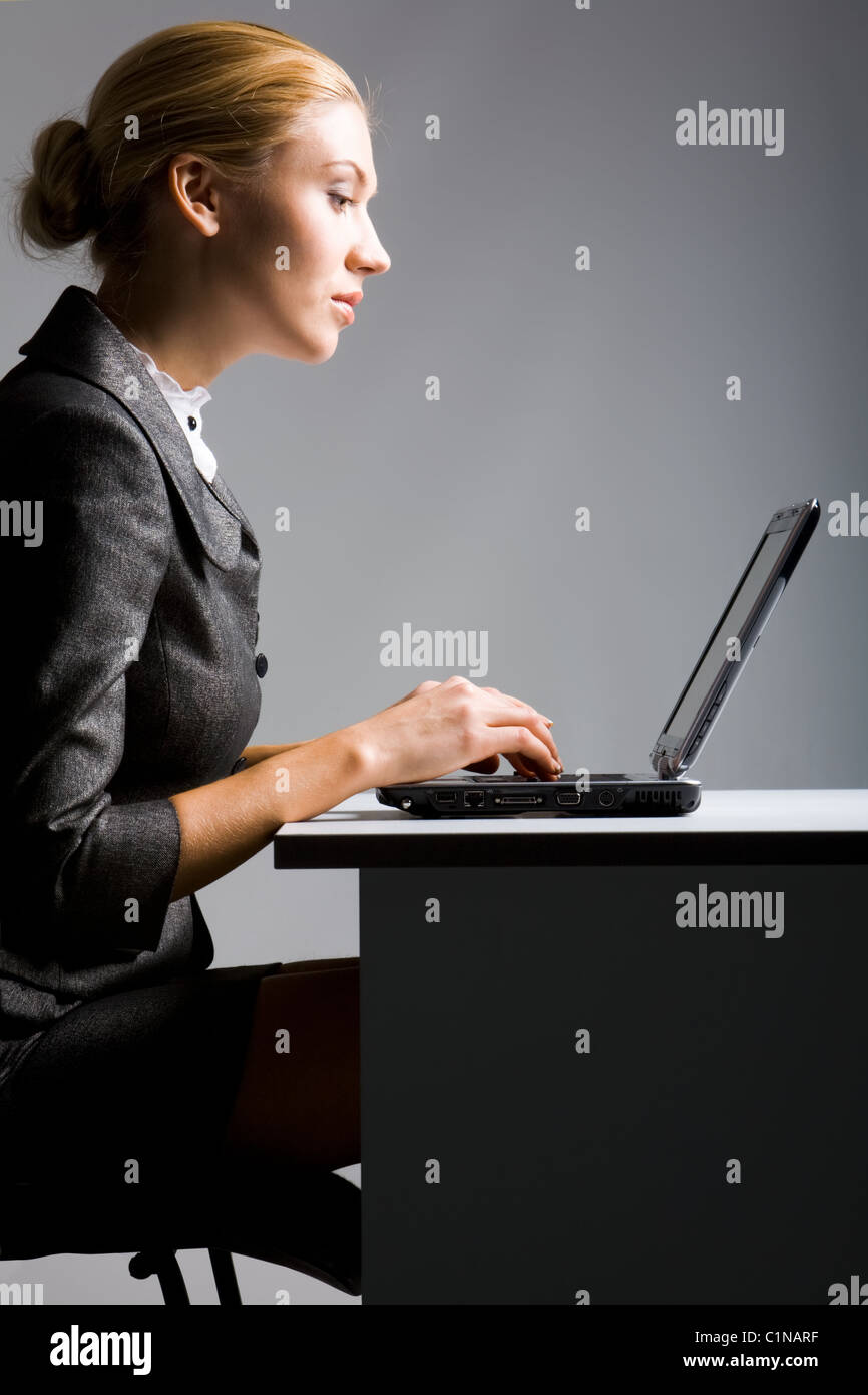 Photo of pretty secretary typing at workplace over grey background ...