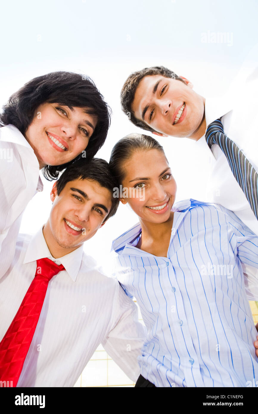 Photo of several successful partners embracing each other and looking ...