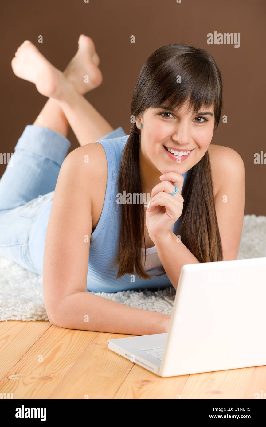 Home study - woman teenager with laptop lying on wooden floor Stock ...