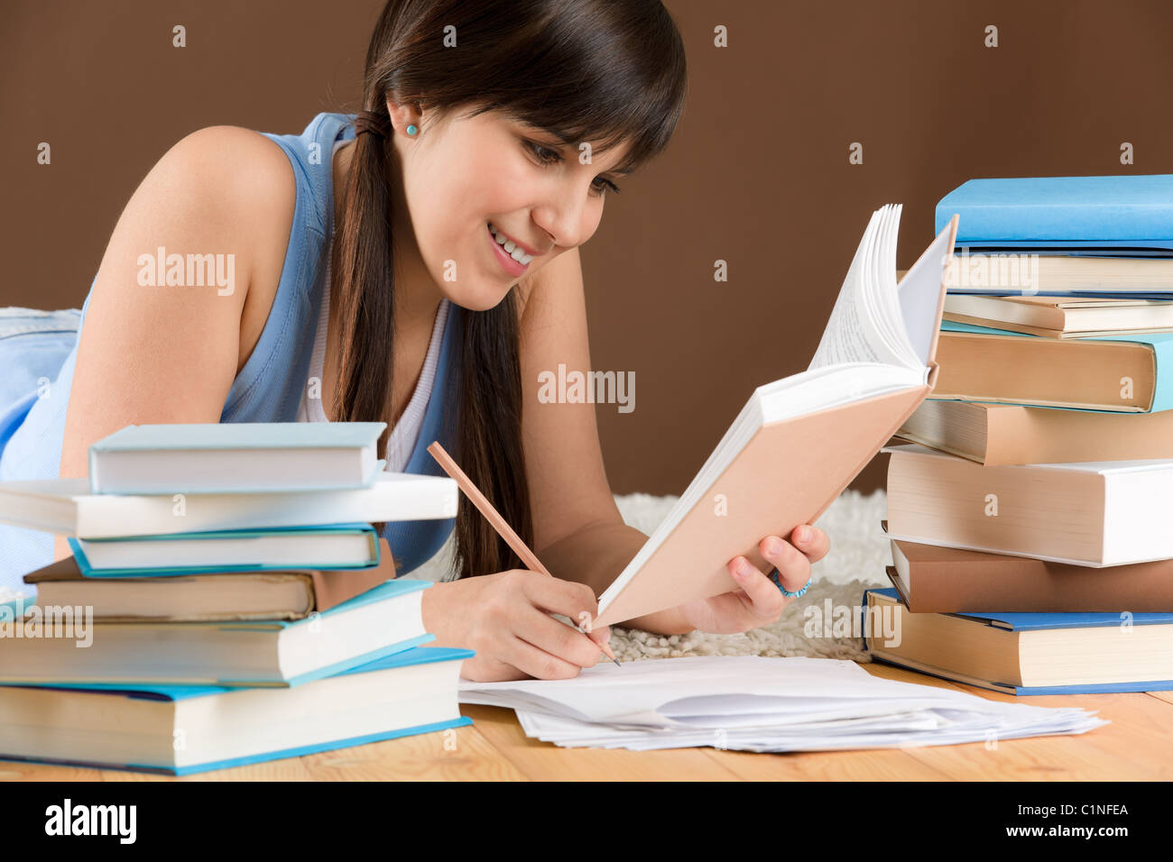 Home study - woman teenager write notes lying on wooden floor Stock ...