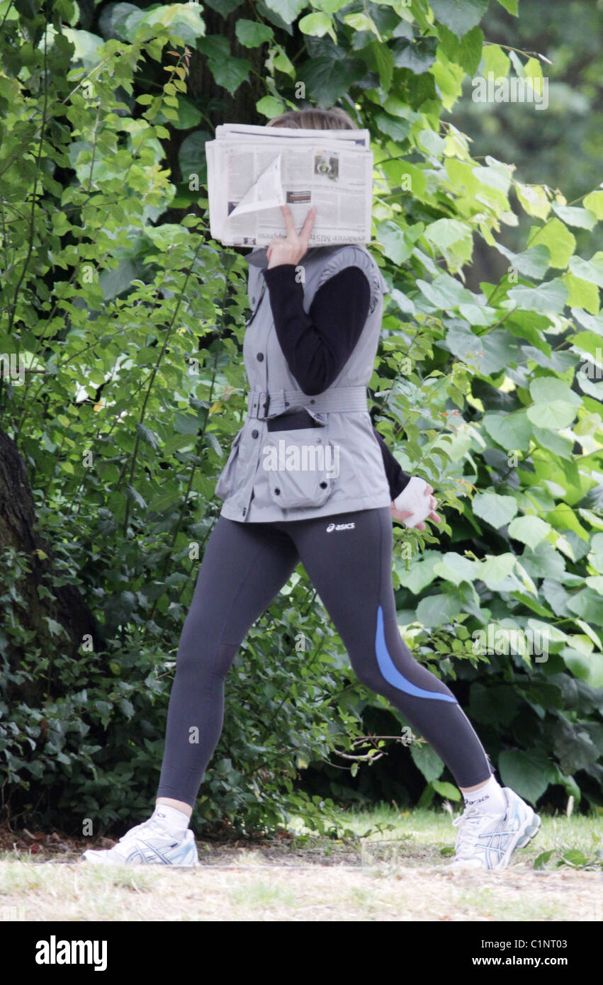 Fiona Phillips hides her face from photographers by holding a newspaper ...