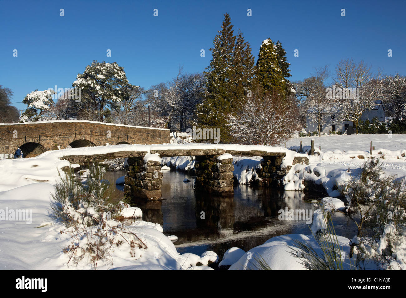 Snow covered Clapper Bridge at Postbridge in Winter on Dartmoor Devon ...